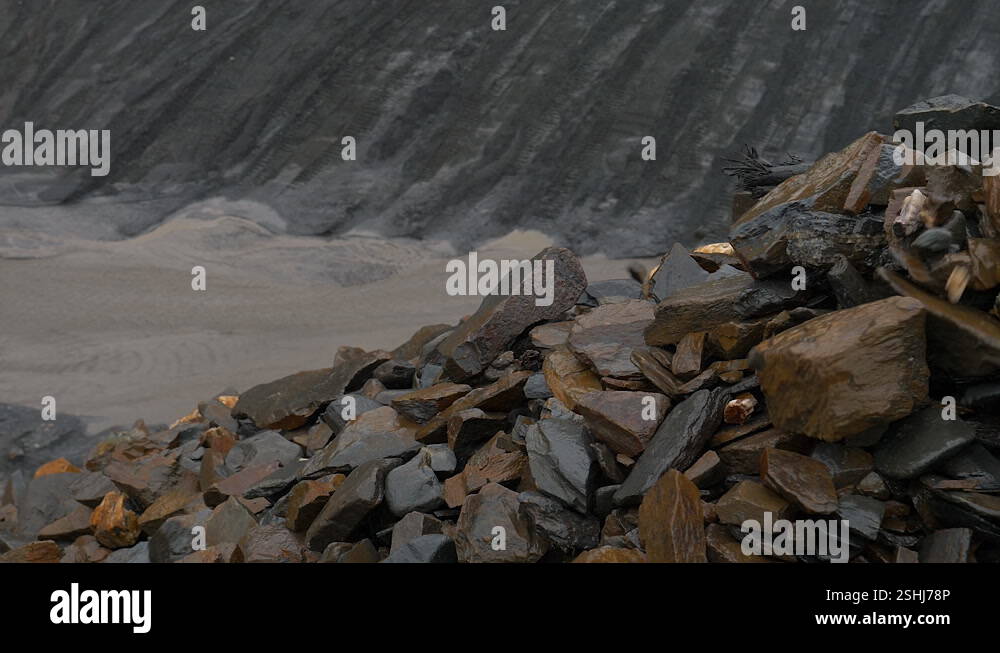 Pouring lots of gathered mineral stones into the pile at the industrial ...