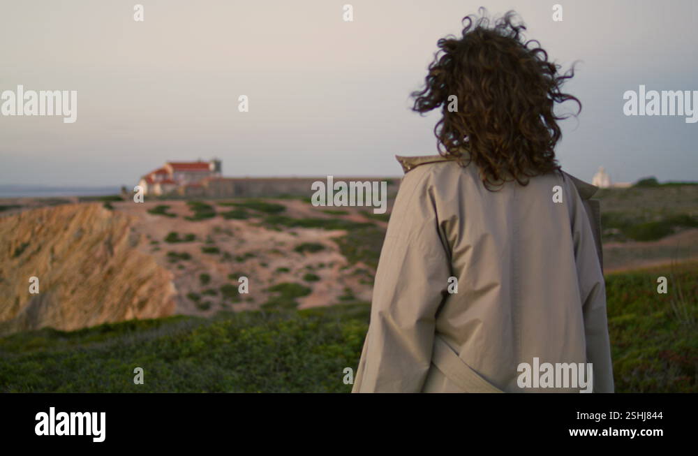 Girl watching ocean cliff on evening. Worried lonely woman ...