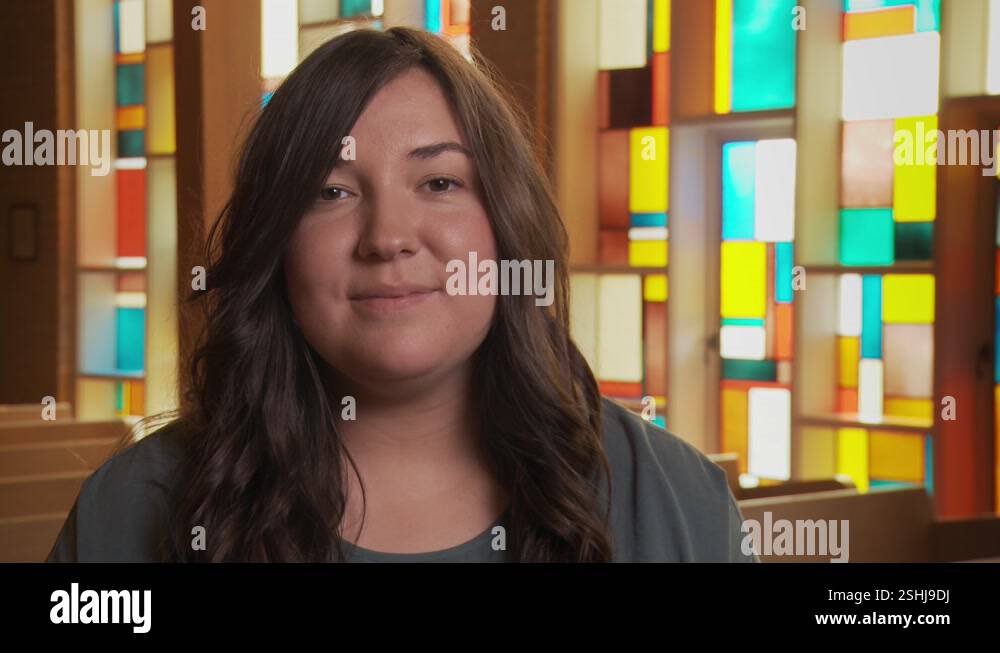 Close up of a pretty young ethnic female smiling at the camera inside a ...