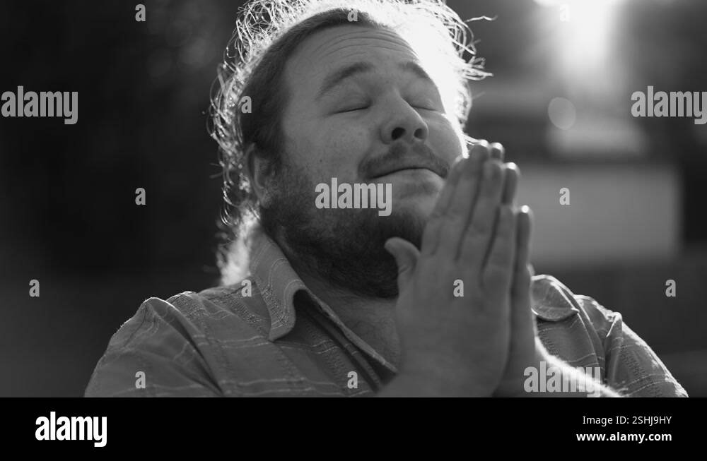 Hopeful young man praying to God outside having FAITH in monochromatic ...