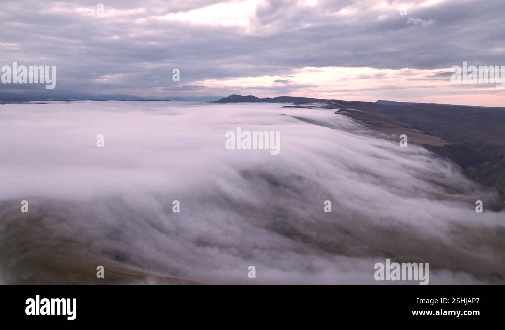 Aerial timelapse view of the movement of low clouds in the mountains ...