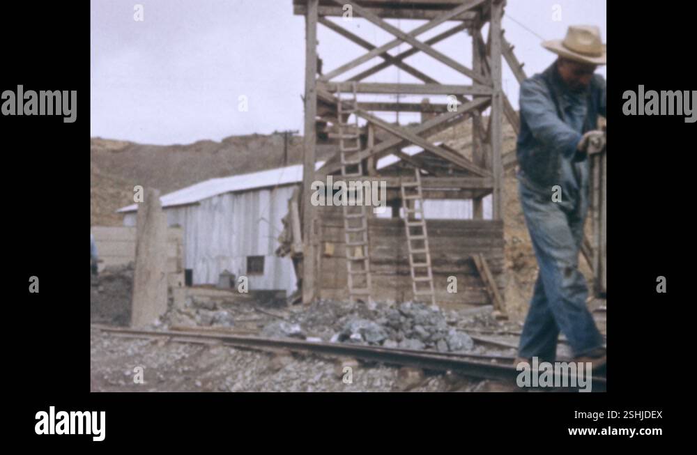 1950s: Workers next to mine entrance push carts. Miners leaving ...