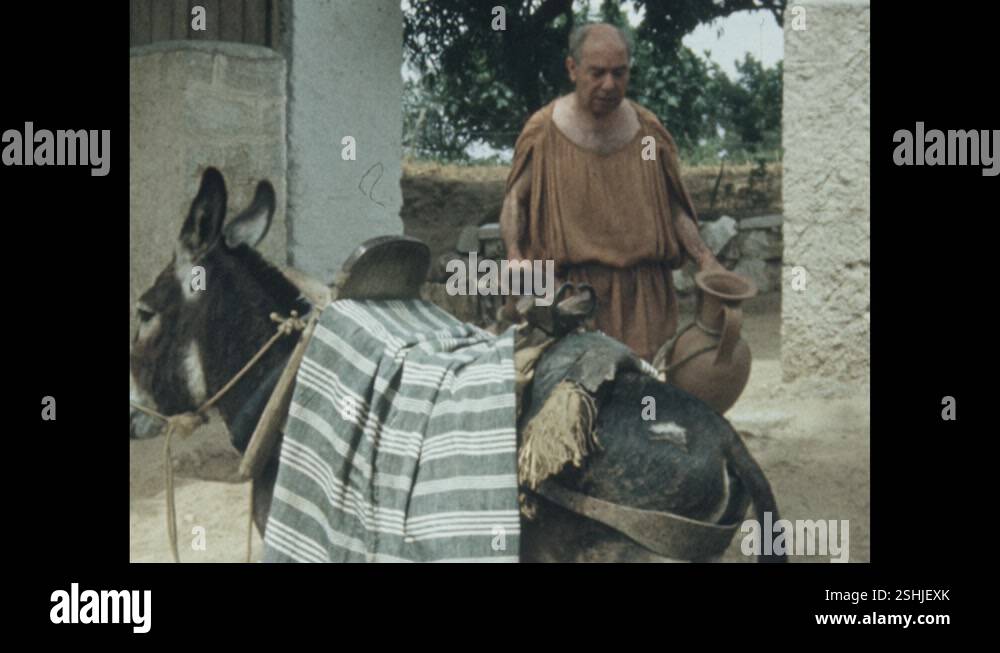 1950s: Donkey waits in courtyard. Two men enter, one loads two urns ...