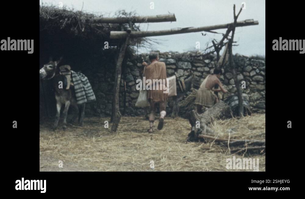 1950s: Man unties donkey and leaves, other man retrieves bag, helps boy ...