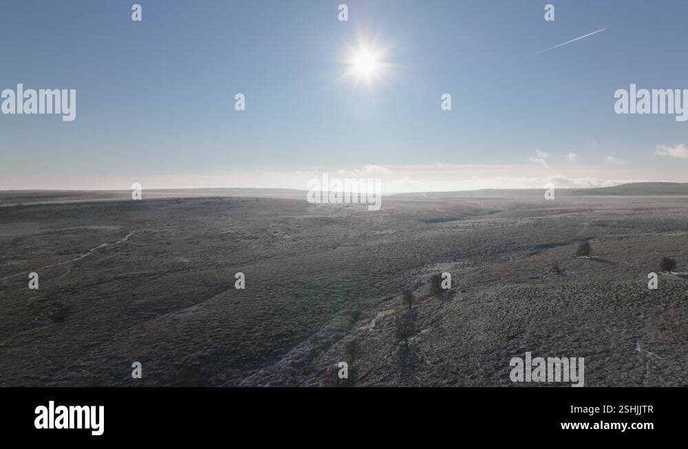Vast snowy, frozen moorland and tundra lit by a low winter sun in a ...