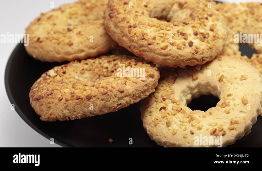 A Ring Of Shortbread Cookies With Peanuts Rotates On A Black Plate On ...