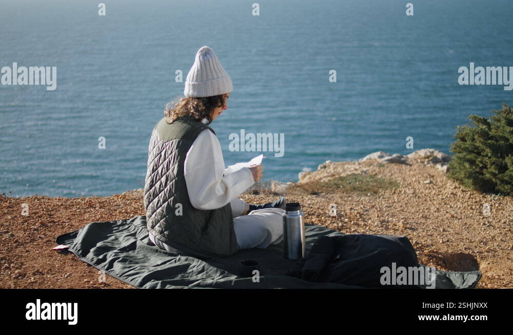 Girl resting ocean cliff picnic on spring vacation. Carefree tourist ...