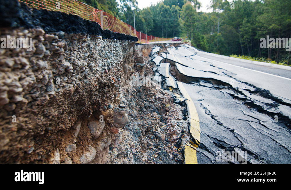 Damaged asphalt road in the mountains. Mudflow aftermath, cracked paved ...