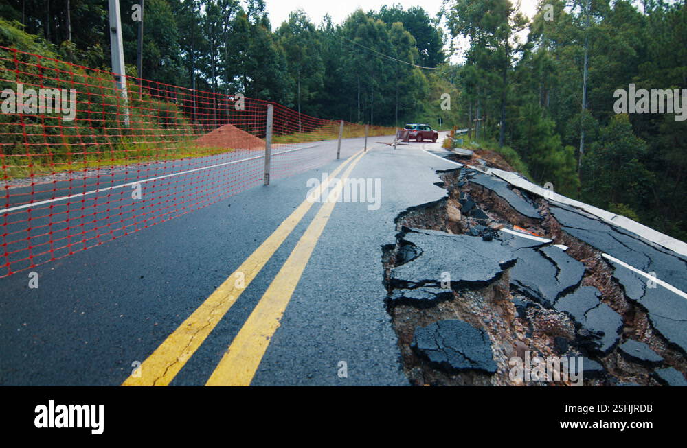 Damaged asphalt road in the mountains. Mudflow aftermath, cracked paved ...