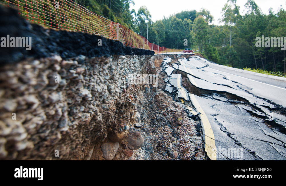 Damaged asphalt road in the mountains. Mudflow aftermath, cracked paved ...