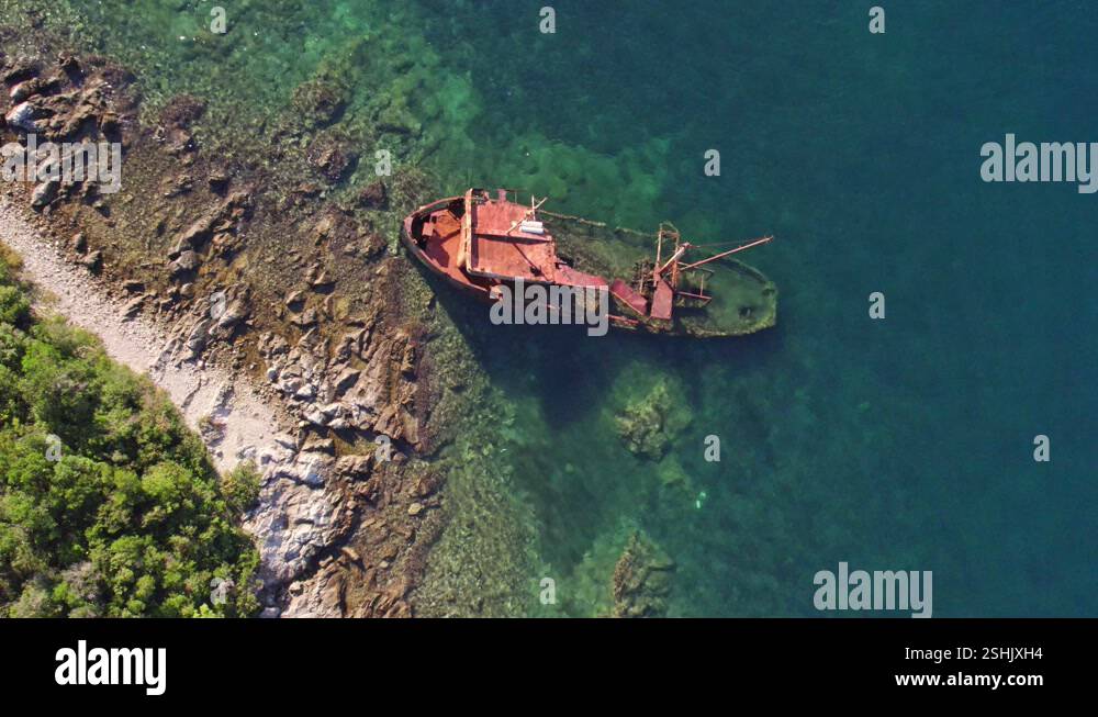 Old broken ship half sunken on shallow blue water shore, top down Stock ...