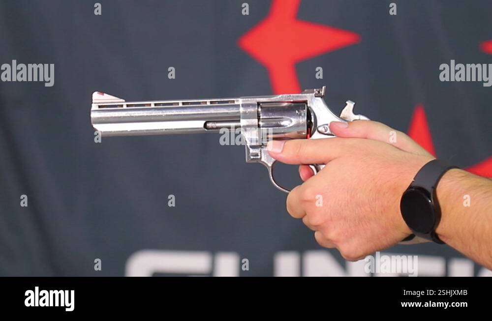 Two-handed grip on a stainless steel revolver - firing one round Stock ...