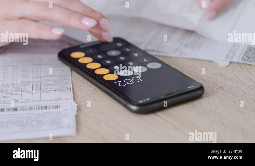 economical woman work on phone calculator at home pay bills taxes on ...