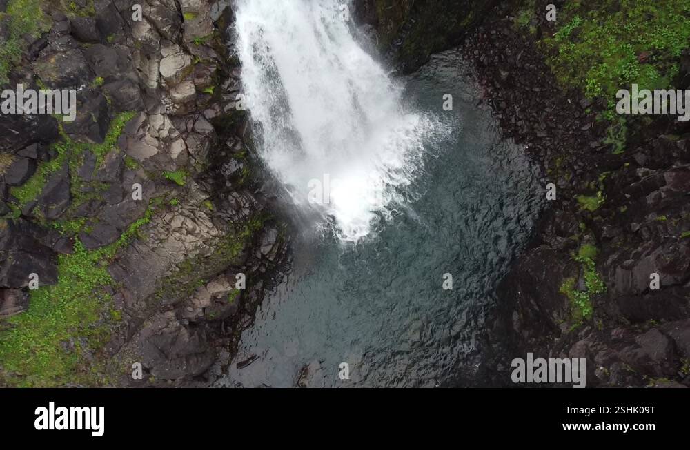 Spectacular Waterfall falling into river water of mountains in Stock ...