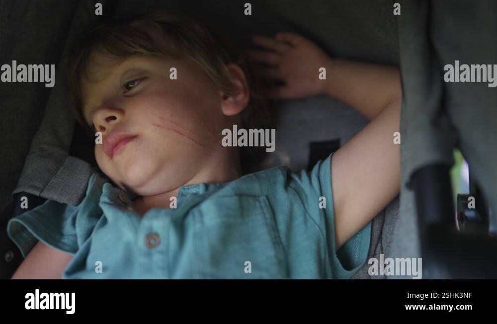 Little boy sitting inside stroller waking up from nap. Child wakes up ...