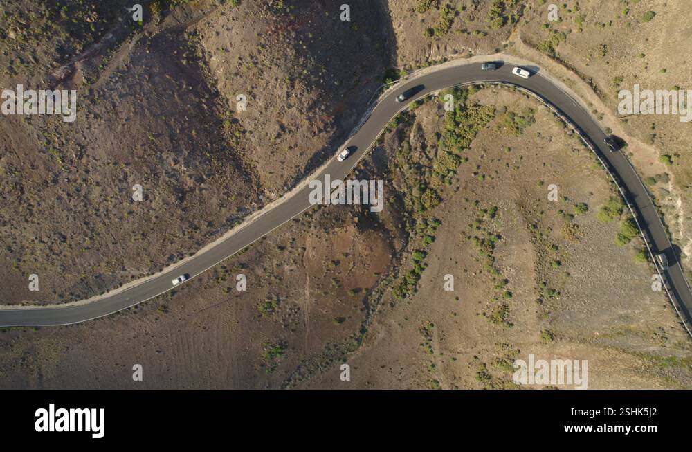 Cars are driving along the tiny Los Ajaches road, Lanzarote, Canary ...