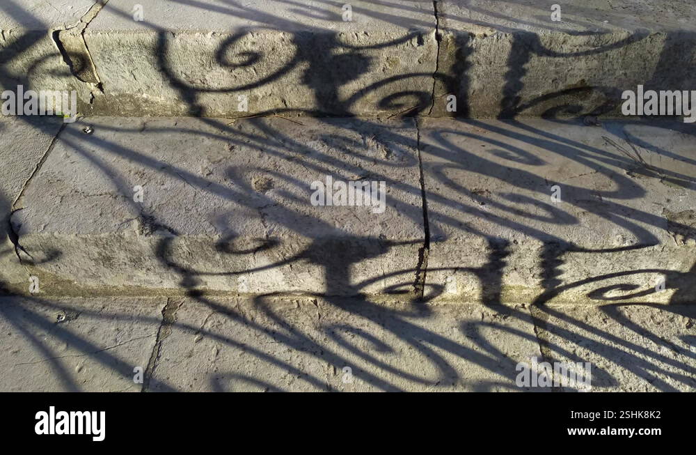 Shadow on stone stairs made of slabs cast by the curved pattern of ...