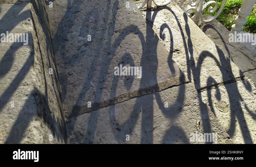 Shadow on stone stairs made of slabs cast by the curved pattern of ...