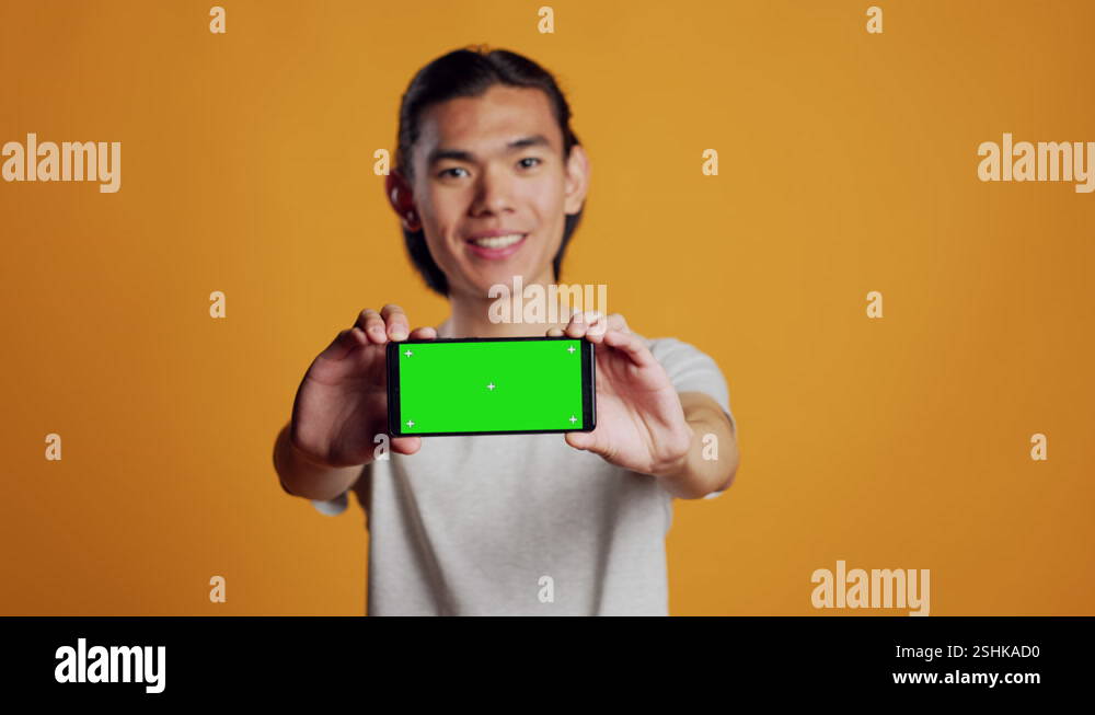 Male model holding horizontal greenscreen mobile phone Stock Video ...