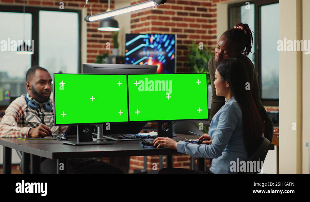Team of diverse workers analyzing computers with greenscreen template ...
