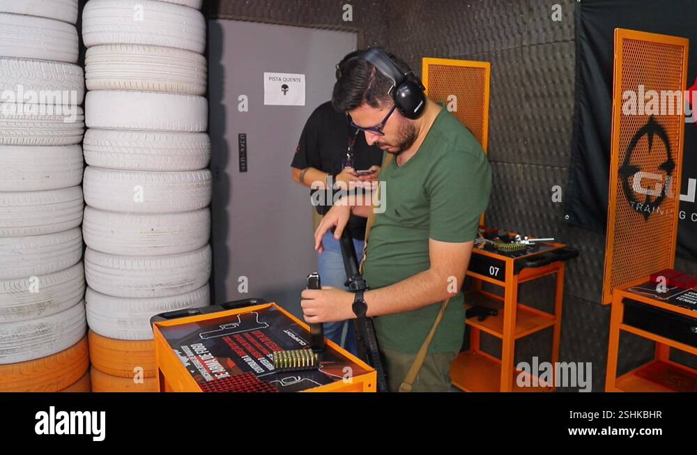 Man loading bullets into a high capacity magazine at a shooting range ...