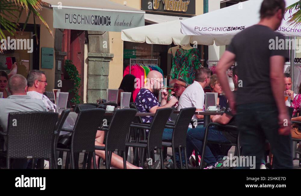 People sit at a sidewalk cafe on Old Square in the city center of Stock ...