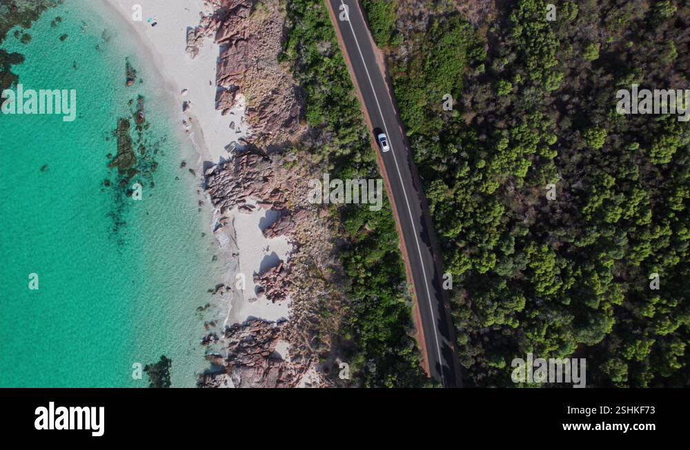 Topdown aerial of car driving next to the crystal clear waters of Eagle ...