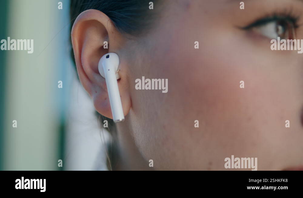 Woman face wireless earbud in ear close up. Portrait girl wearing ...