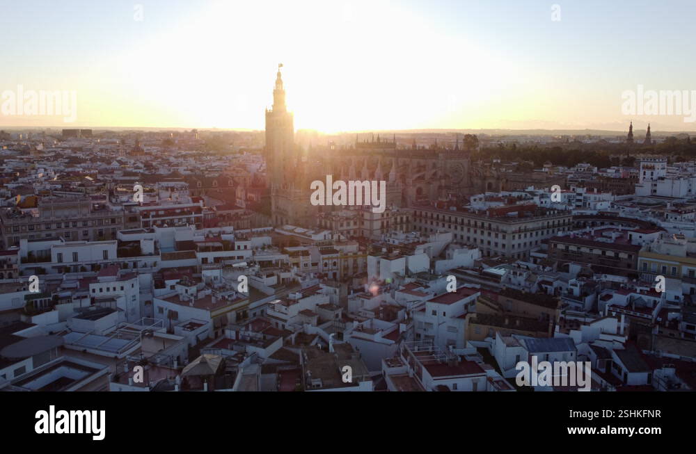 Cinematic bright sunset behind Seville Cathedral, Spain; drone push-in ...