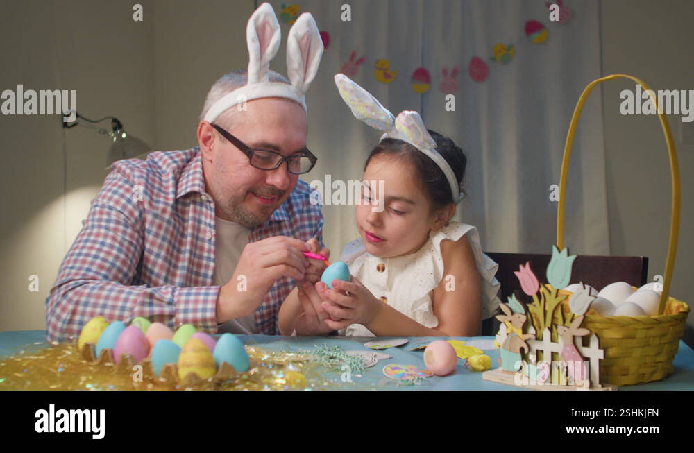 Happy Father and Daughter Color Easter eggs at home at the table Stock ...