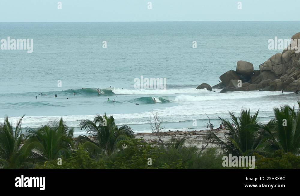 Static shot of people surfing on turquoise waters on a beach in Mexico ...