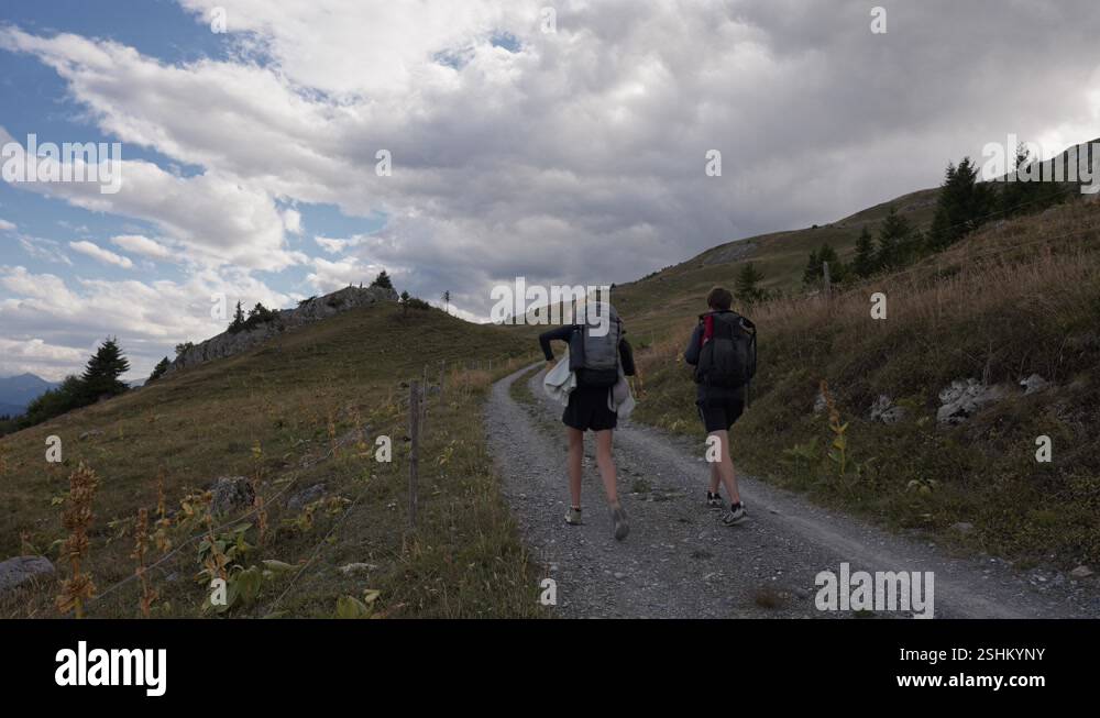 Couple hiking in the mountains of Switzerland dramatic clouds Stock ...