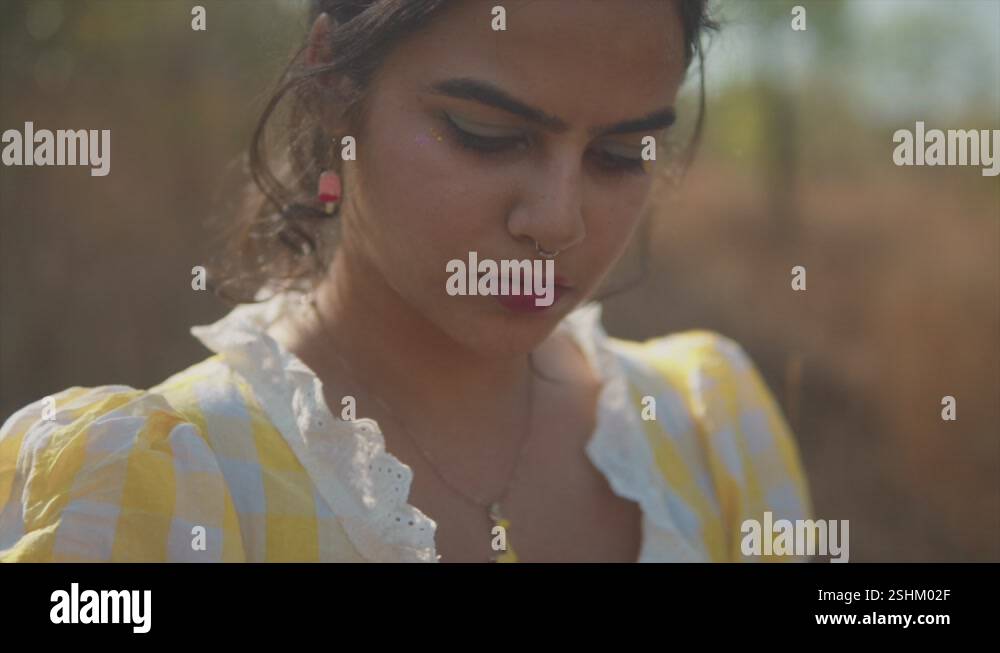 A close up shot of the face of an attractive Asian female glancing down ...