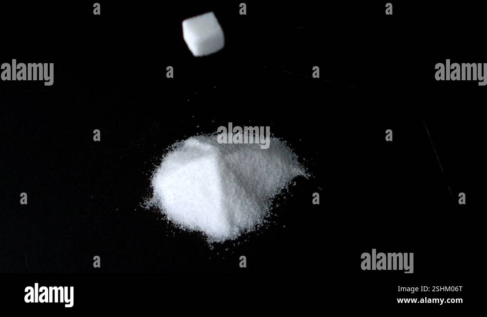 Sugar cube falling into pile of sugar on black surface Stock Video ...
