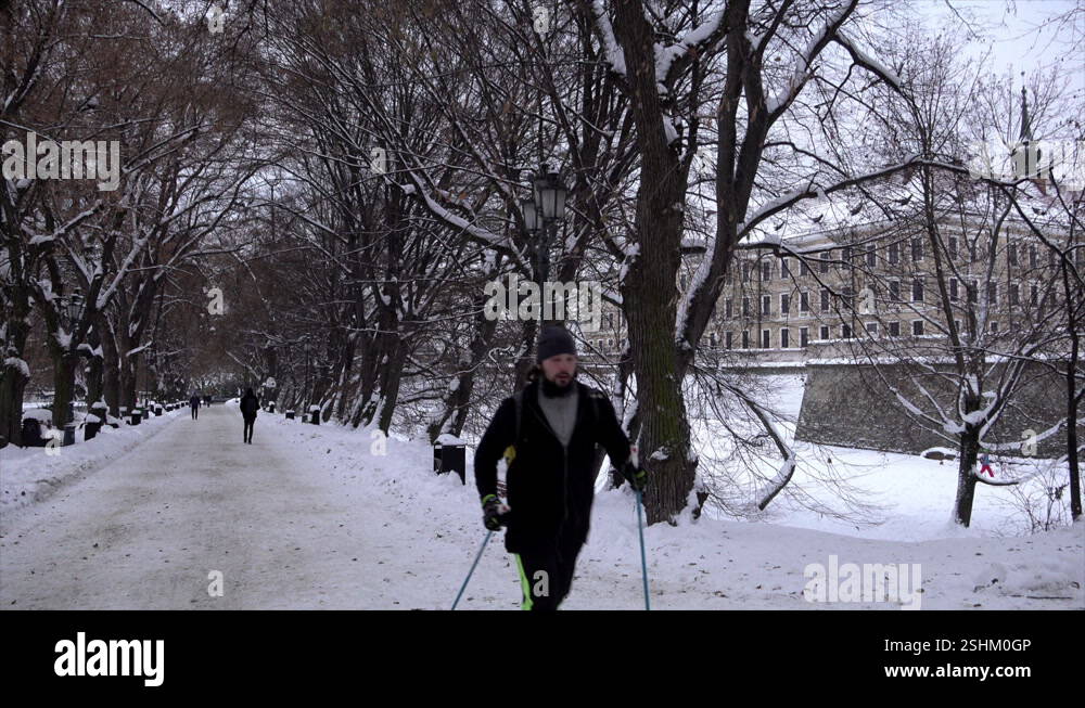 A man uses skis with sticks to get along a snow covered pathway in ...