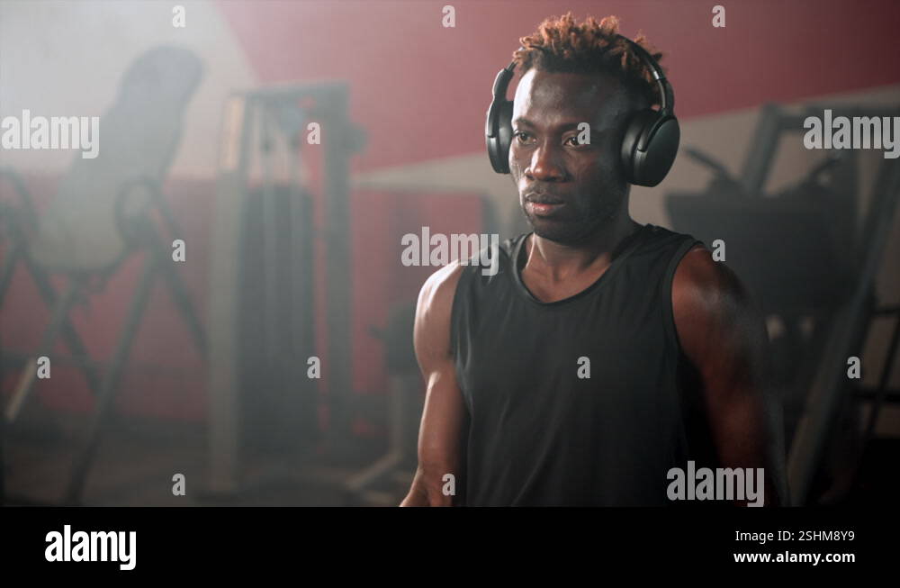 Black man exercising with dumbbells and listening to music Stock Video ...