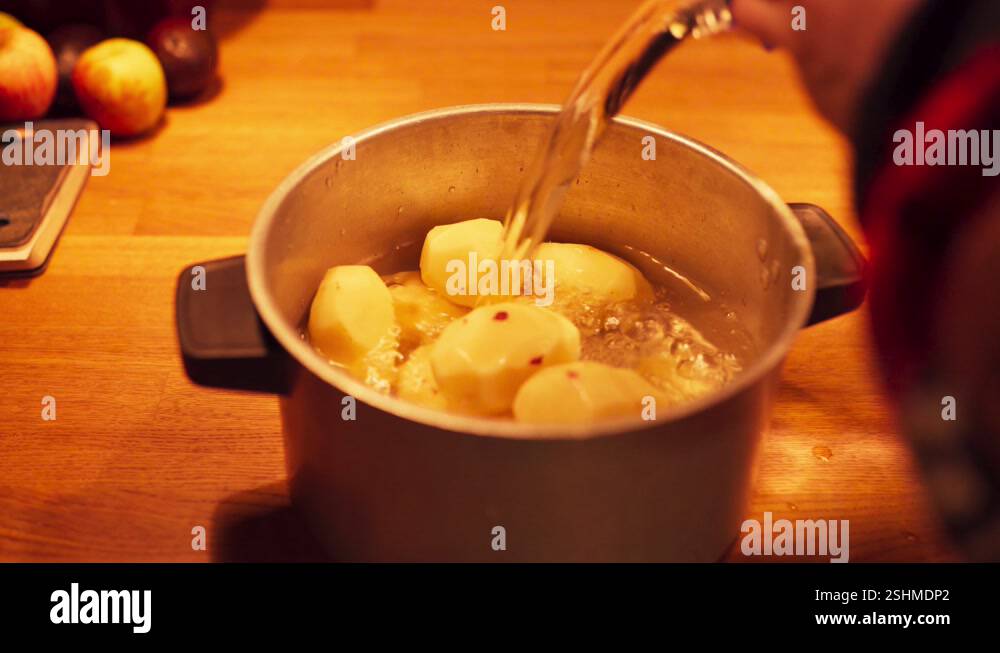 Pouring Water In A Pot With A Pile Of Peeled Potato. Close Up Stock ...