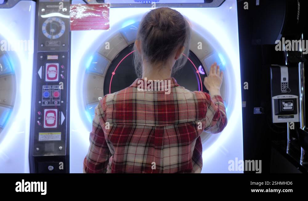 Woman gamer playing in Japanese arcade rhythm game machine Stock Video ...