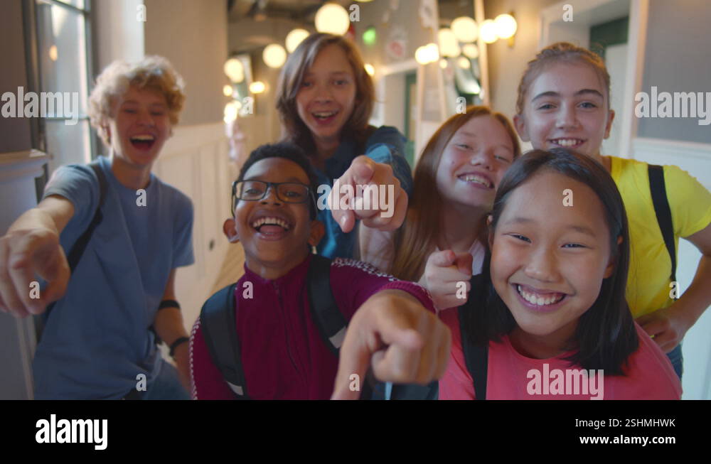 Multiethnic teen students point at camera and laugh. Realtime Stock ...