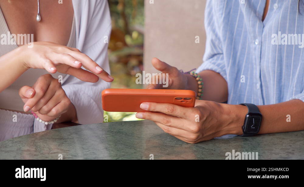 Two recognizable women pointing at the smartphone screen with their ...
