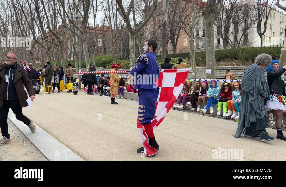 Static view of a costumed acrobat in the street waving and waving a red ...