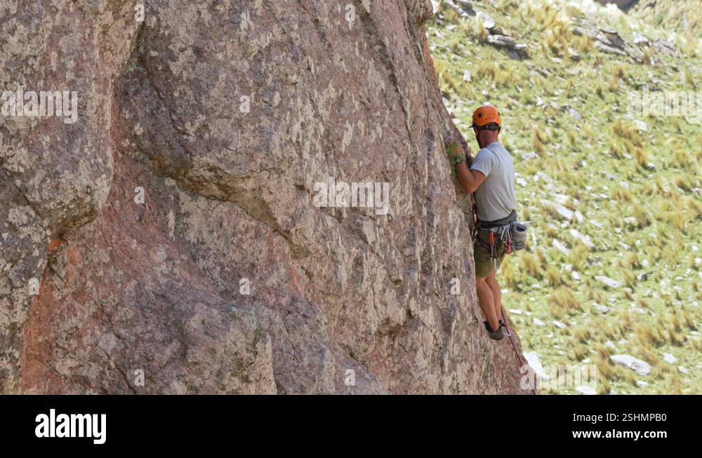 A Middle-Aged Man rock climbing on a wall. Comechingones mountains ...