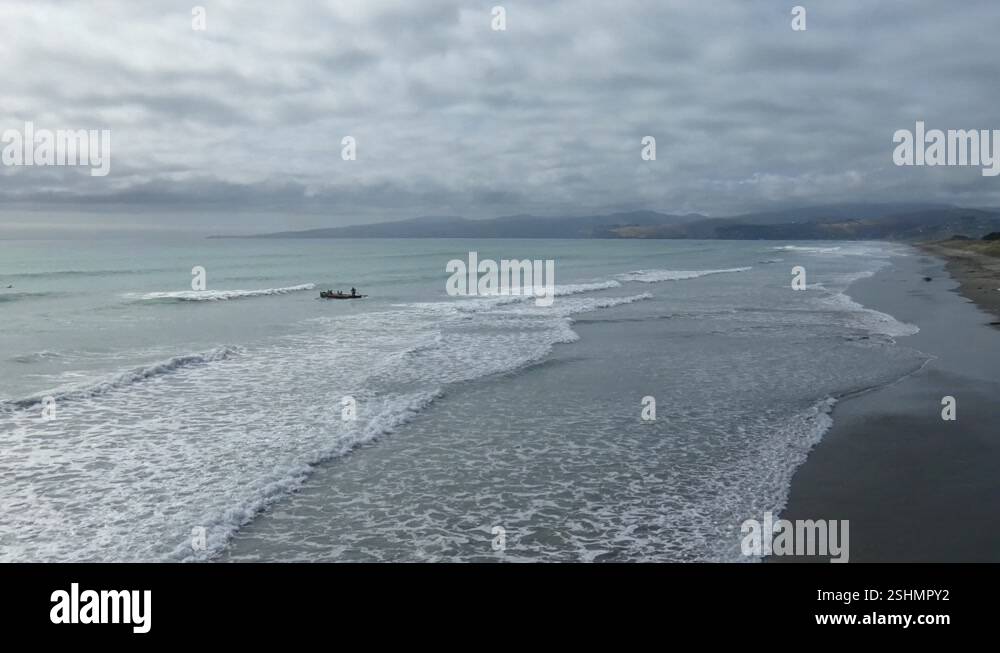 Surf life saving crew row through waves on an in-coming tide - New ...