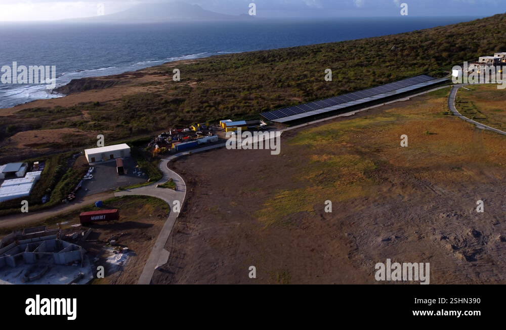 Aerial Panning Shot Of Solar Panels And Construction Site On Cliff By ...