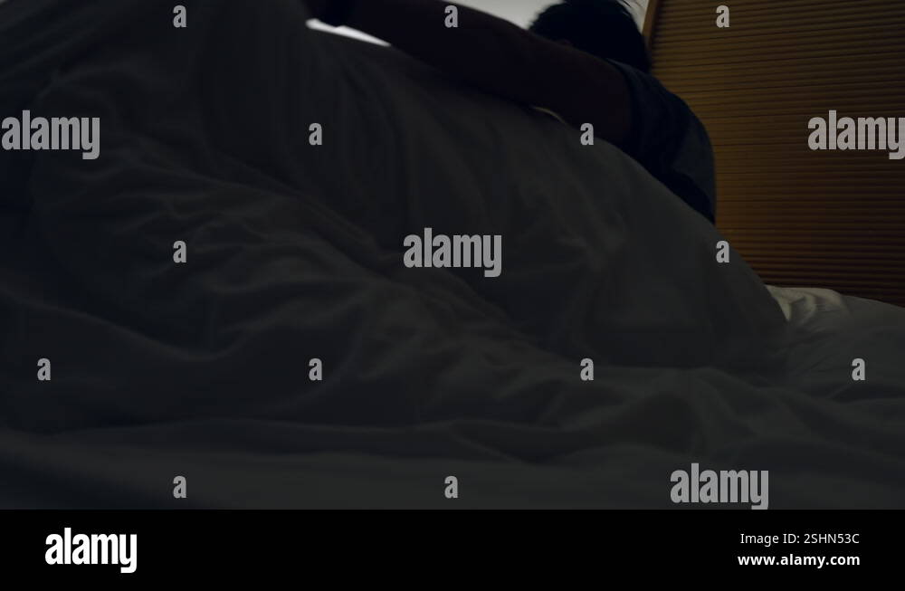 Man waking up getting out of bed in the middle of the night. Early wake ...