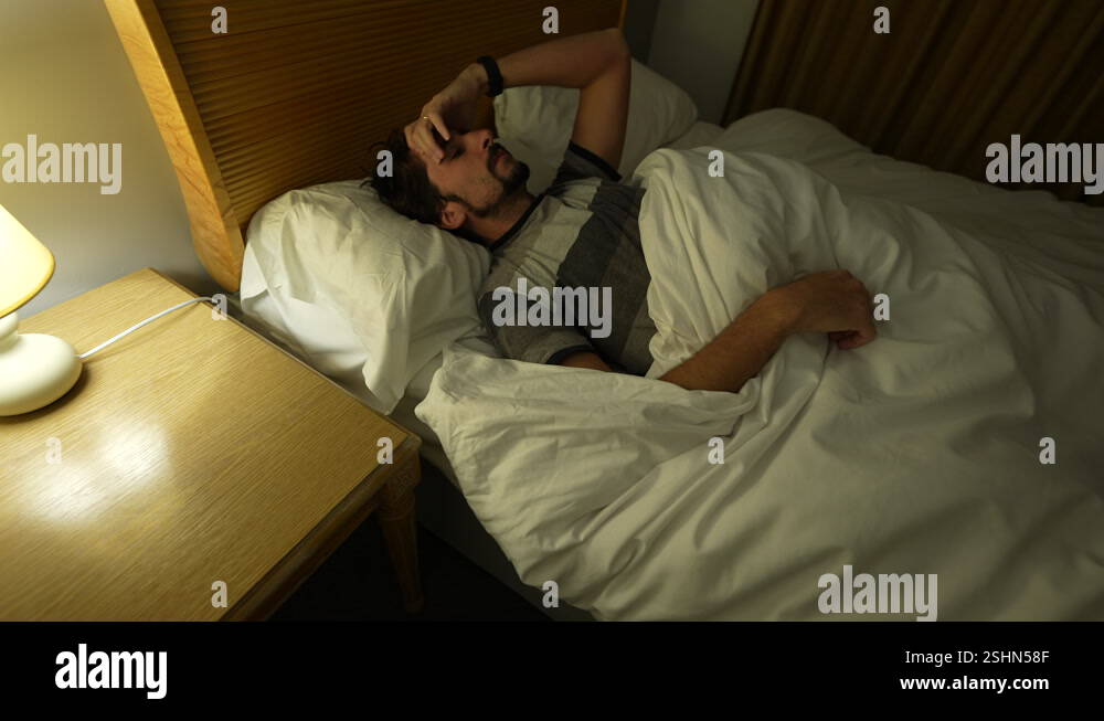 Man waking up getting out of bed in the middle of the night. Early wake ...