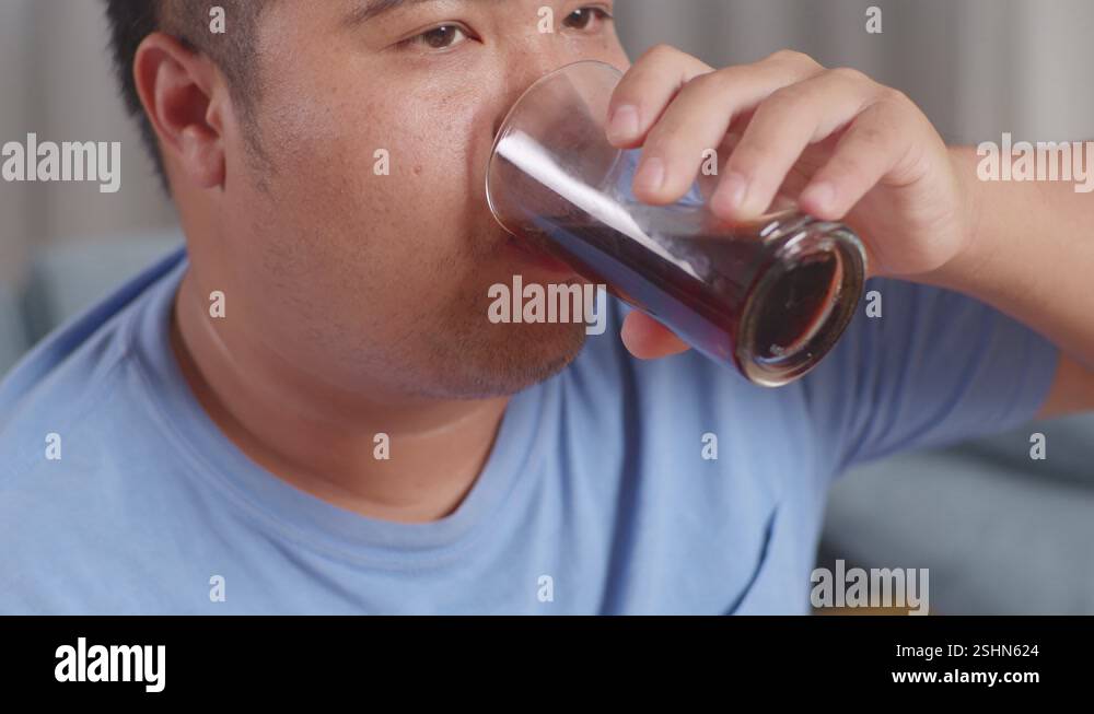 Close Up Of A Fat Asian Man Drinking A Glass Of Coca Cola While Eating ...