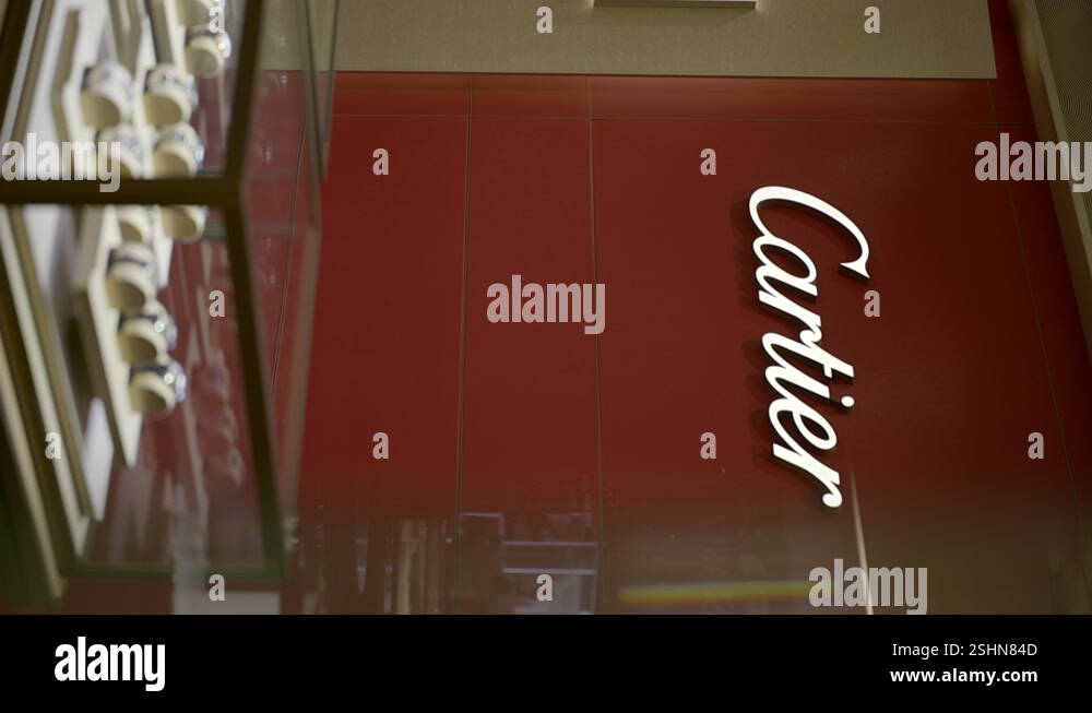 Watch display and Cartier logo glowing on wall, vertical view Stock ...
