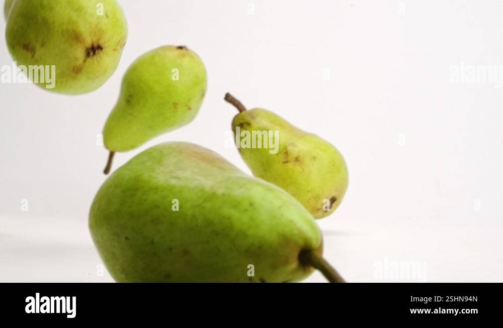 Whole pears bouncing in slow motion on white studio backdrop in 4k ...
