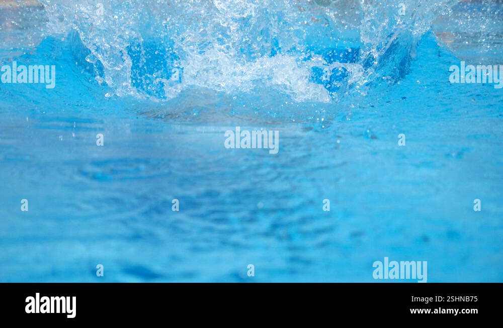 Young attractive woman diving in pool and then emerges from under the ...